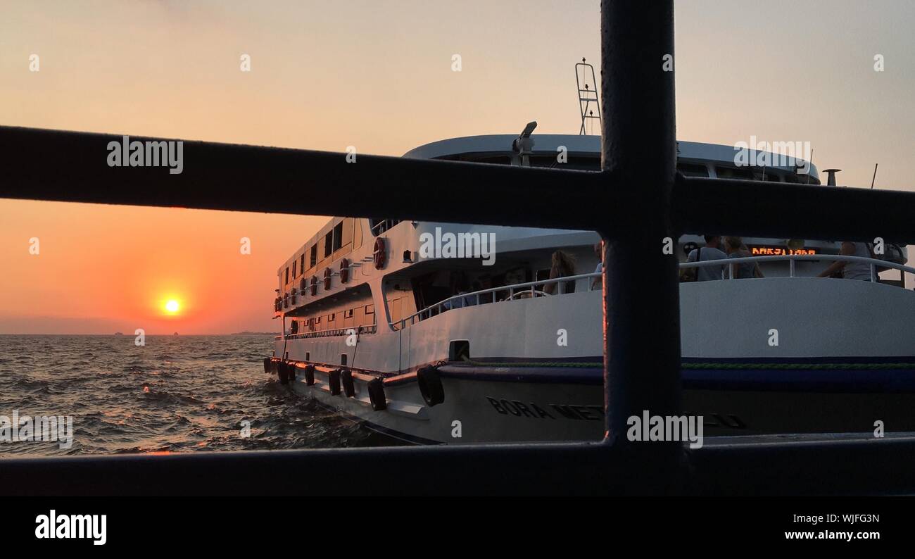 Wide shot of a white boat on the body of water during sunset Stock ...