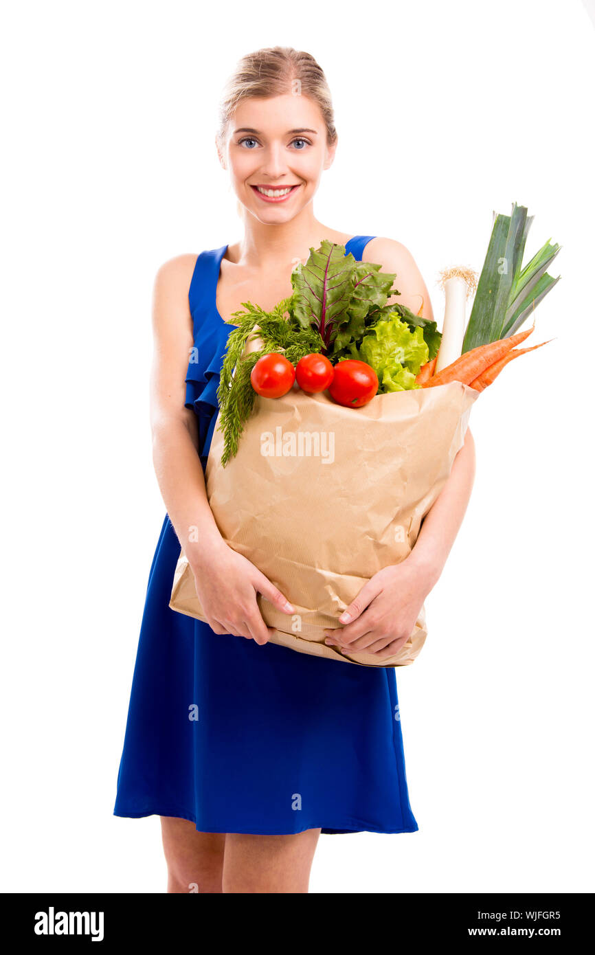 Beautiful and attractive woman carrying a bag full of vegetables ...