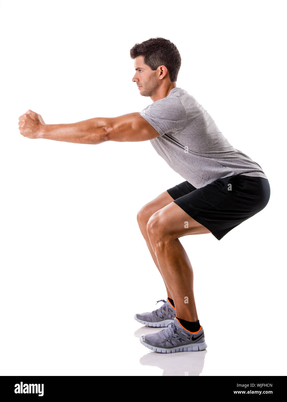 Athletic man running doing squats, isolated over a white background ...