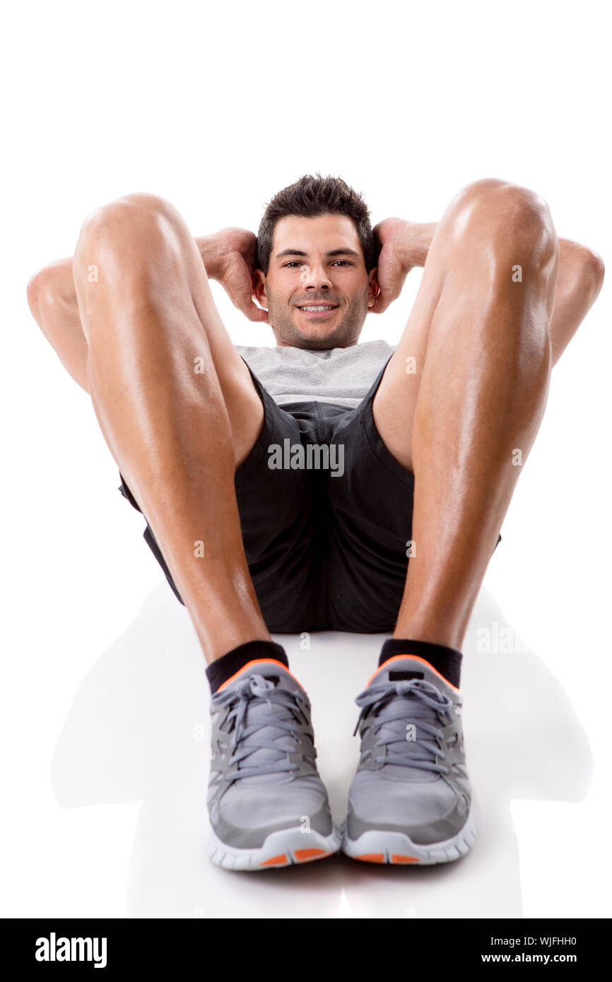 Athletic man running doing abdominals, isolated over a white background ...