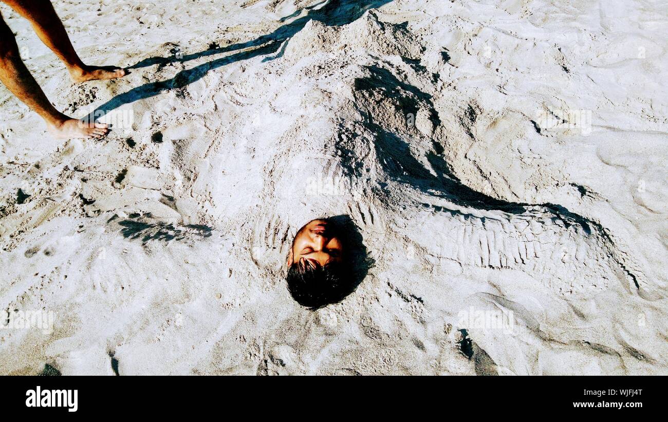 Man buried in the sand hi-res stock photography and images - Alamy