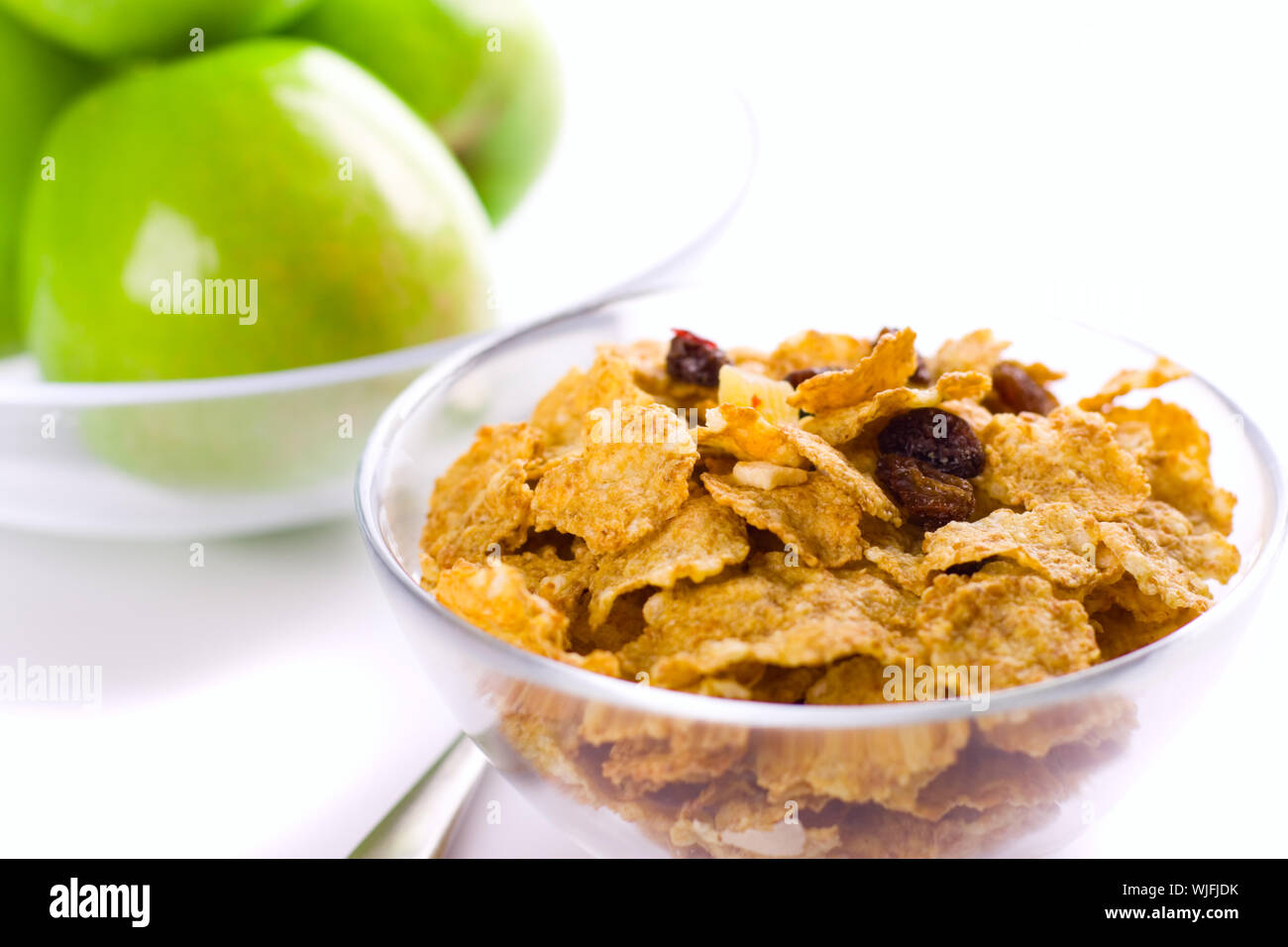 cornflakes and green apples in glass bowls on white background Stock ...