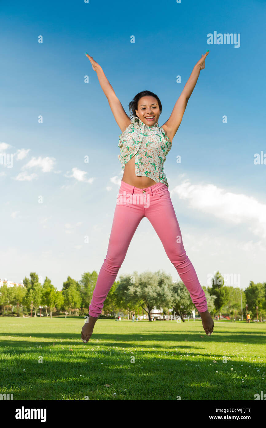 Outdoor portrait of a beautiful African American woman jumping Stock ...