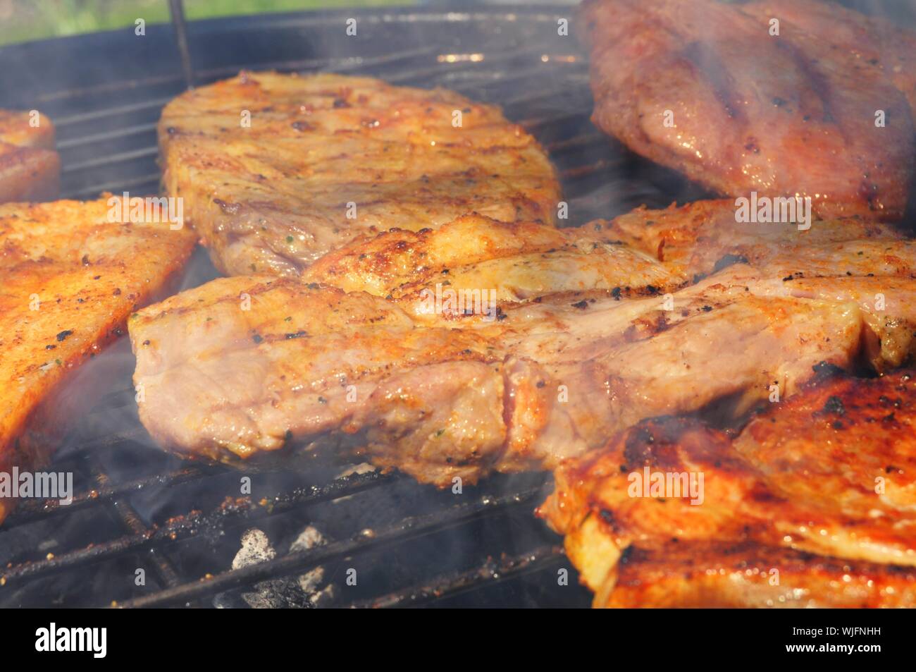 meat on the barbecue in summer showing food concept Stock Photo - Alamy