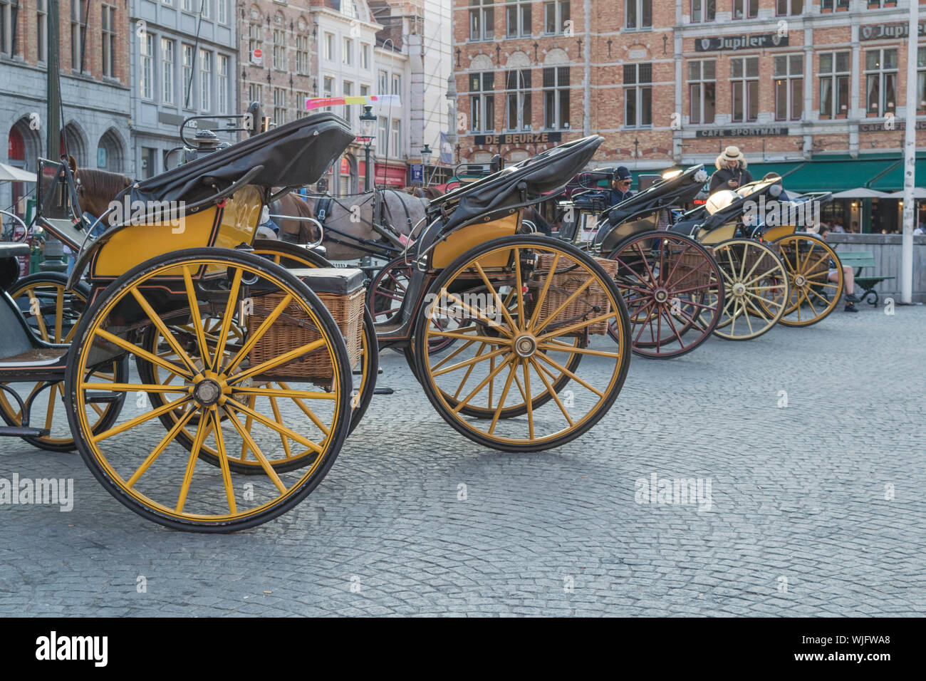 Yellow carriages and carriage wheels in a row, in the center of the ...