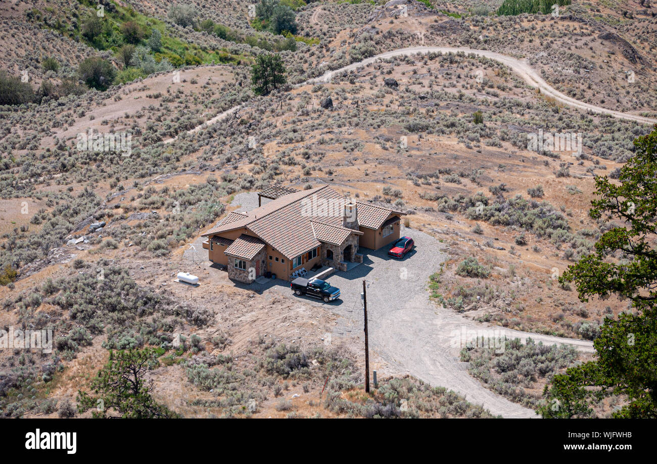 Rancho house with cars parked beside in the middle of desert with ...