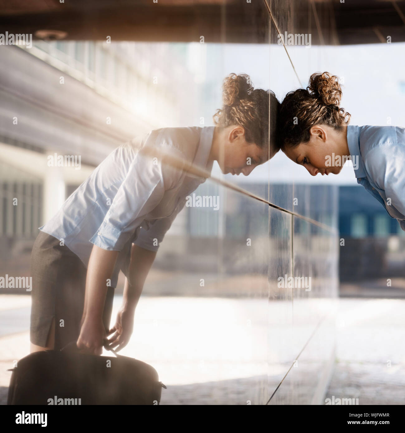 mid adult italian woman banging her head against a wall outside office ...