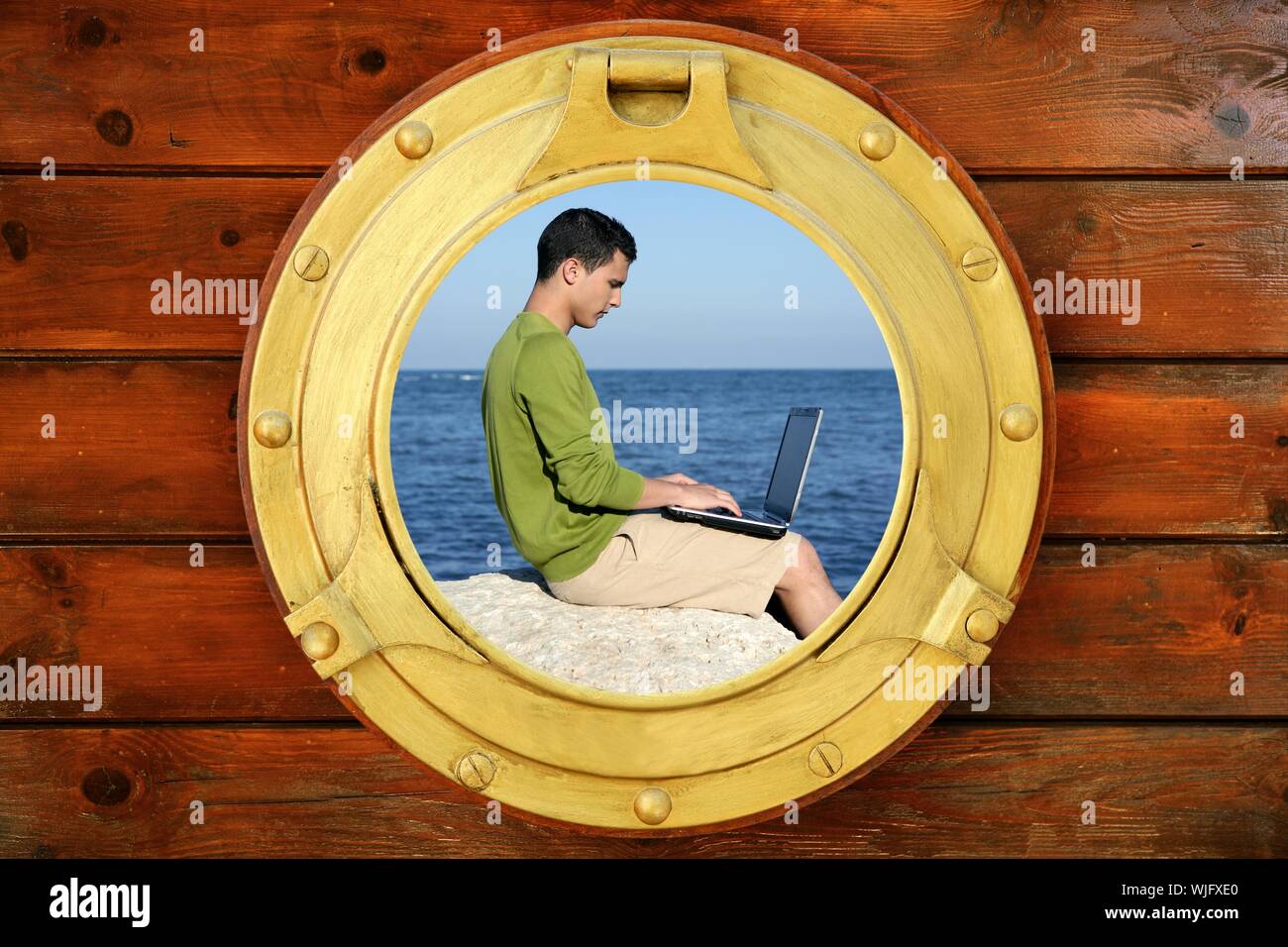 Businessman with computer on the beach, view from round boat window ...