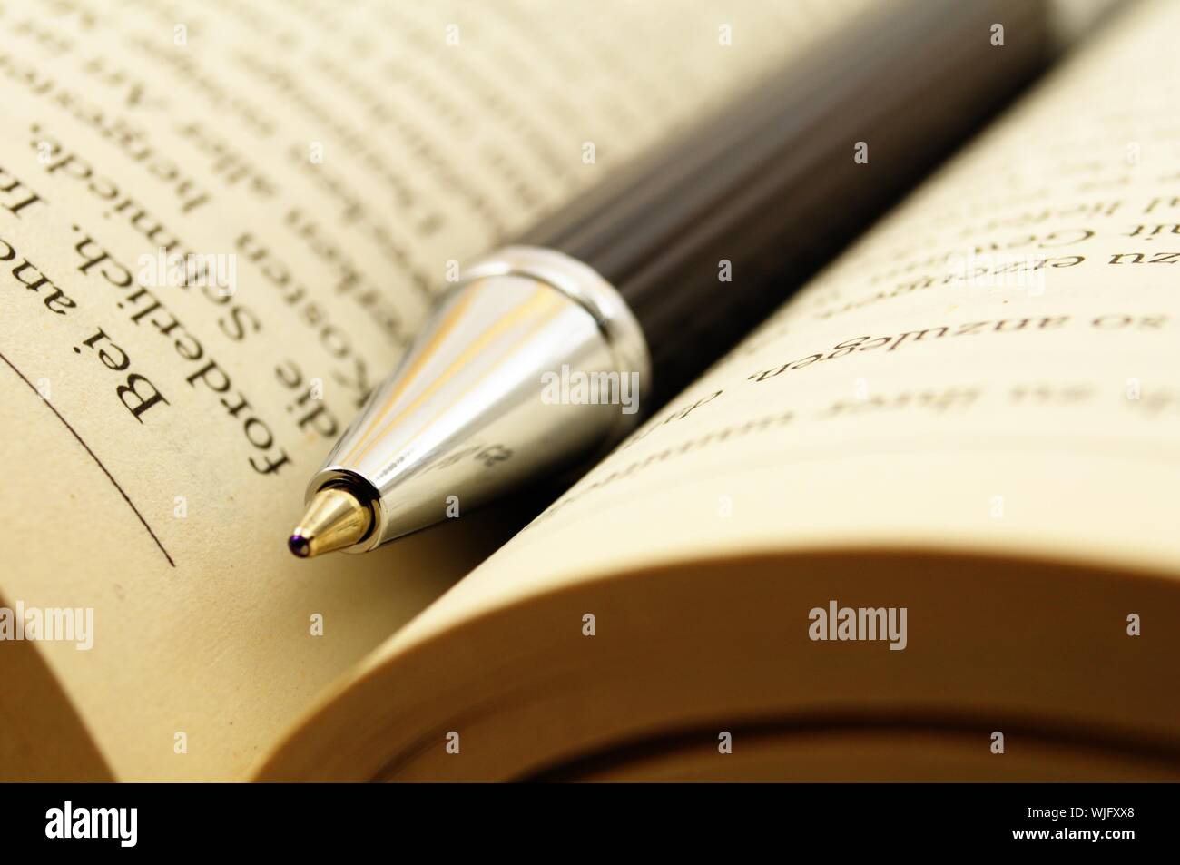 education or reading concept with book and pen Stock Photo - Alamy