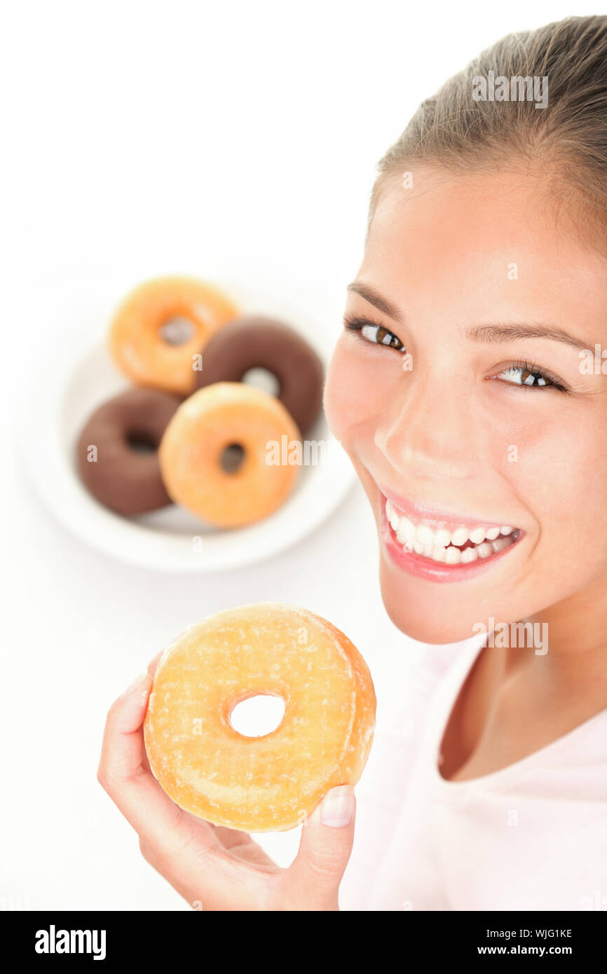 Donuts. Woman eating donut smiling on white background Stock Photo - Alamy