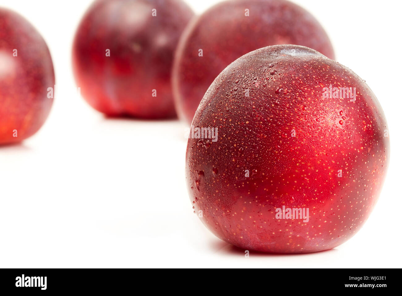 wet plum in front of others on white background Stock Photo - Alamy