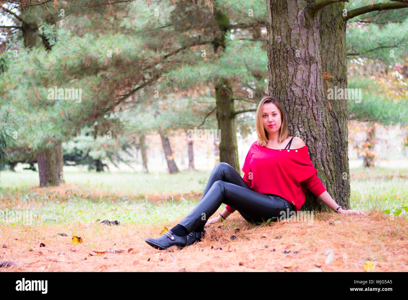 Woman Sitting Against Tree Trunk High Resolution Stock Photography and ...