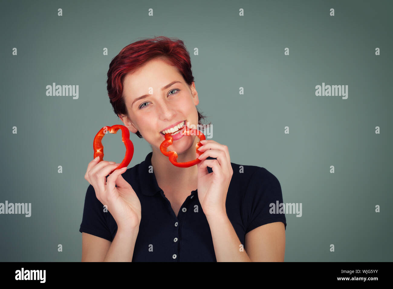 happy redhead woman bites in a slice of pepper Stock Photo - Alamy