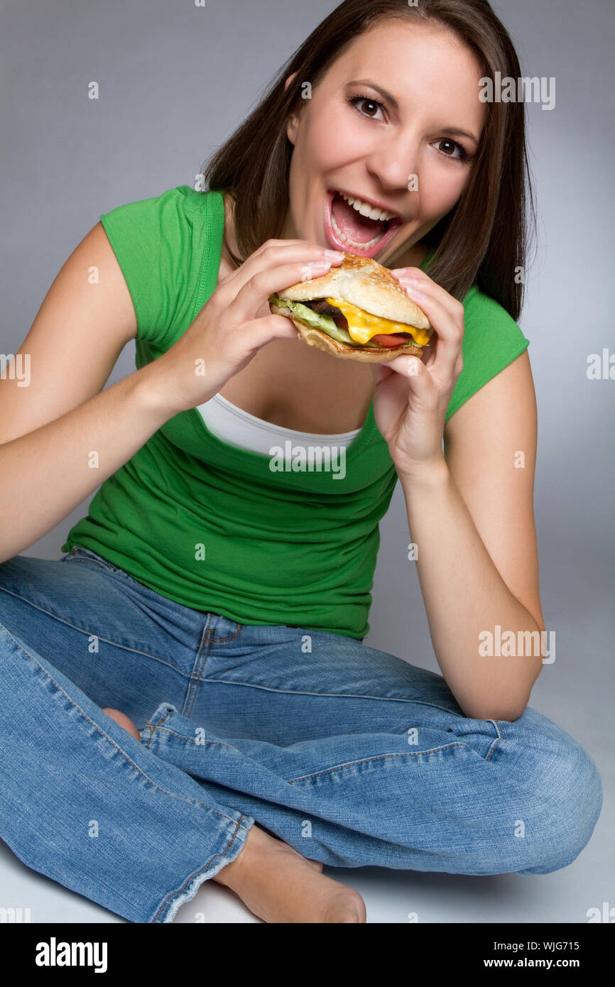 Pretty girl eating burger food Stock Photo - Alamy