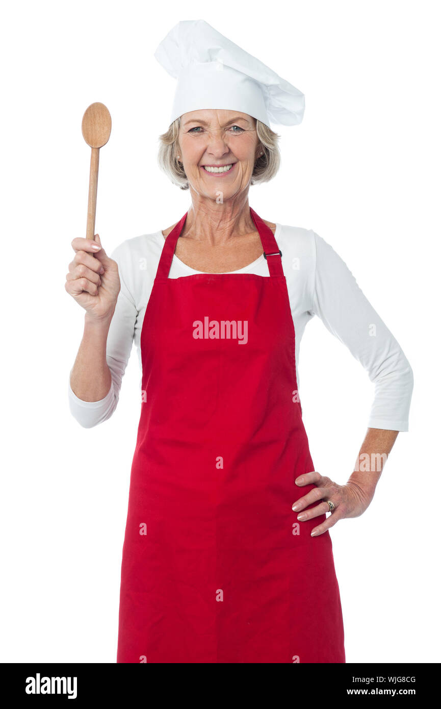 Joyous smiling aged female chef holding spoon Stock Photo - Alamy