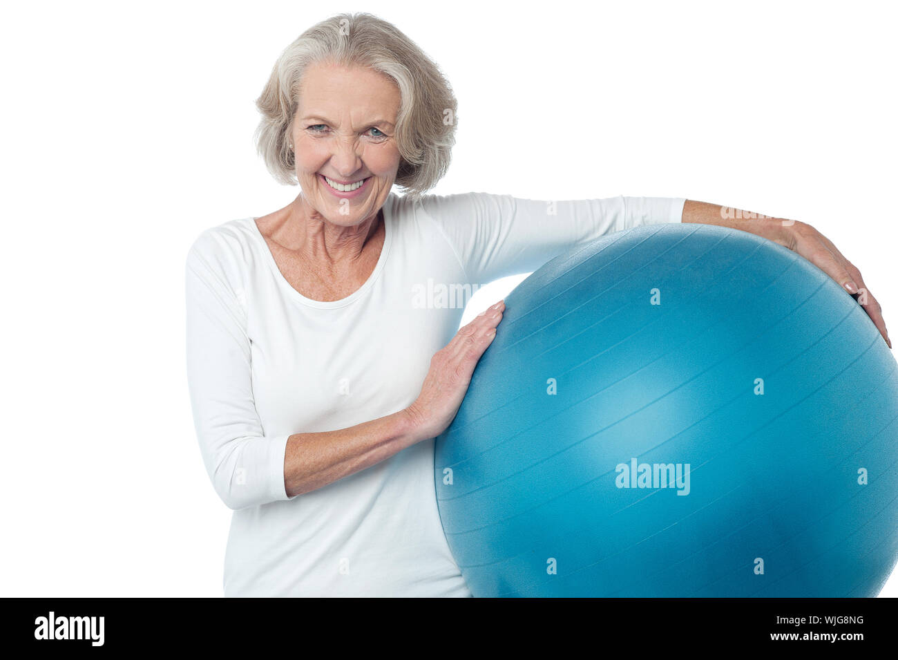 Fit aged woman holding big blue exercise ball Stock Photo - Alamy