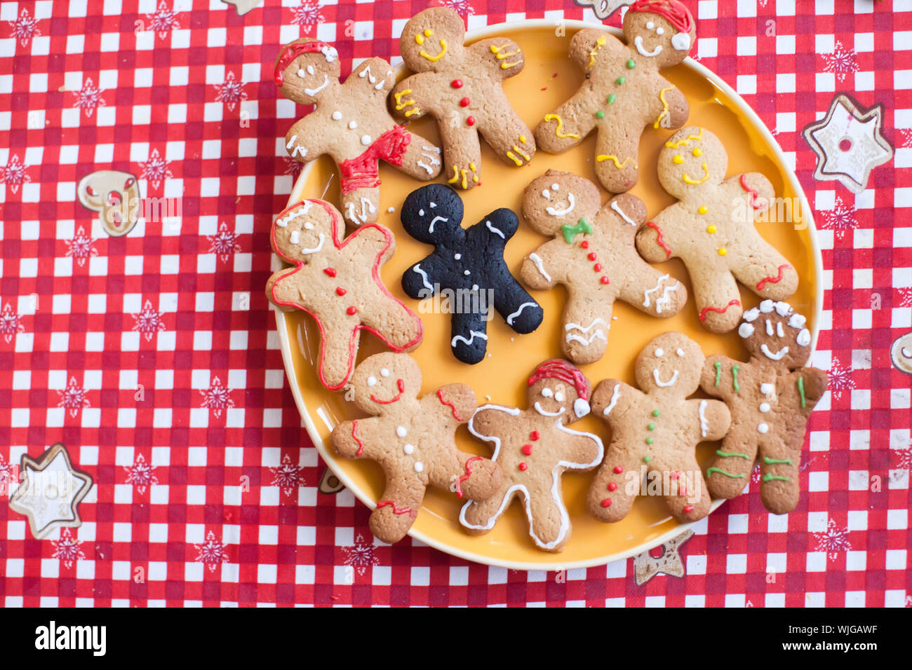 Sad burnt gingerbread man among finished with colored glaze Stock Photo ...