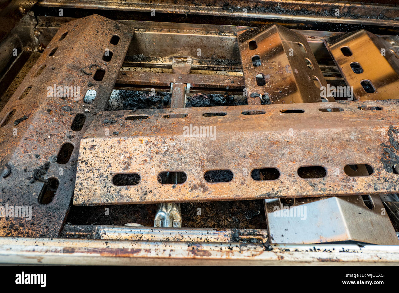 Fuel elements of a gas barbecue rusted and contaminated Stock Photo - Alamy