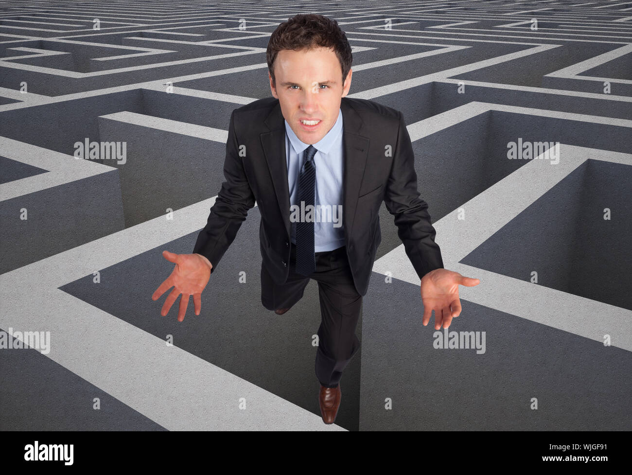 Businessman posing with arms out against difficult maze puzzle Stock ...