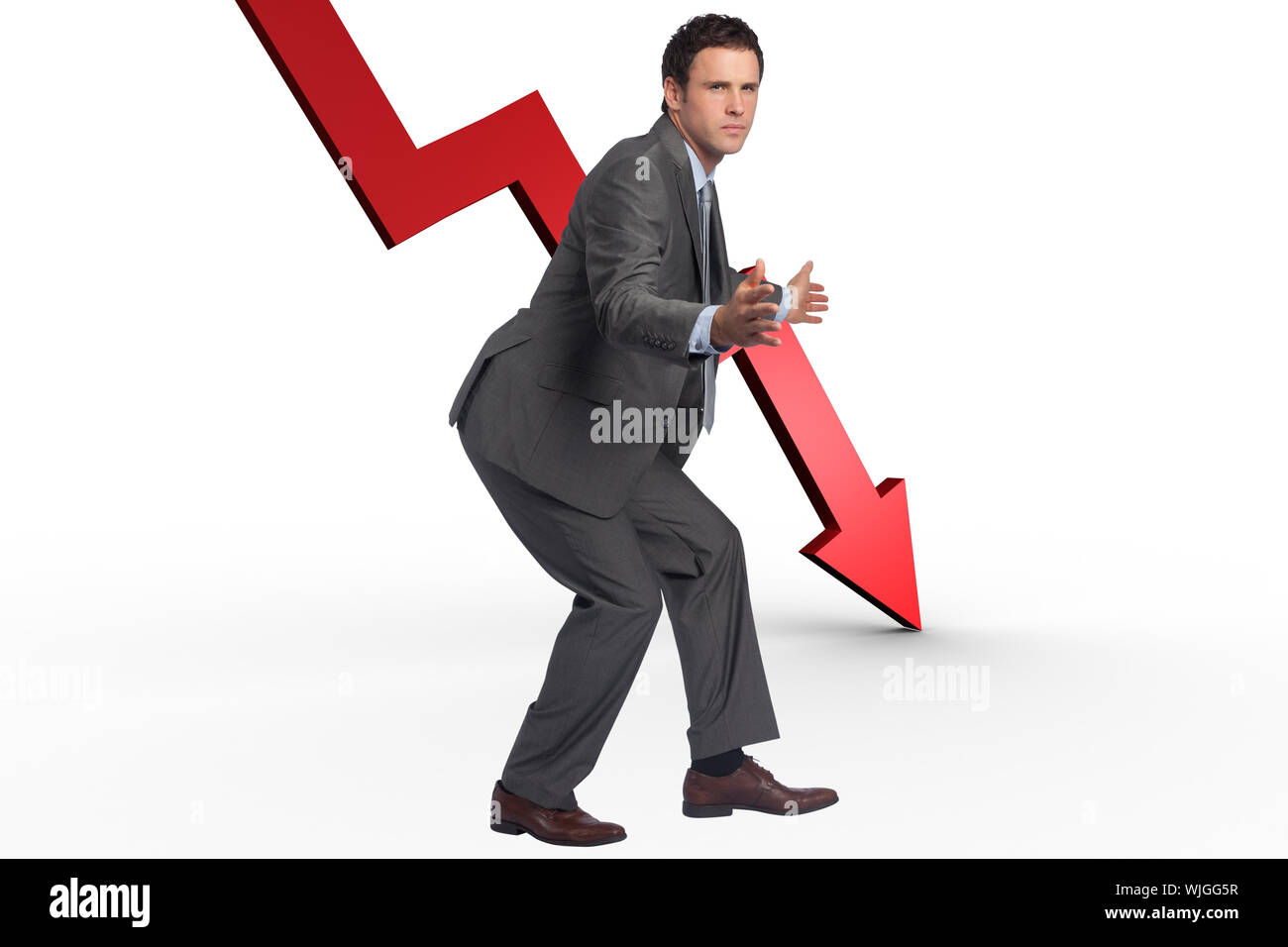 Businessman standing with arms out against red arrow pointing down ...