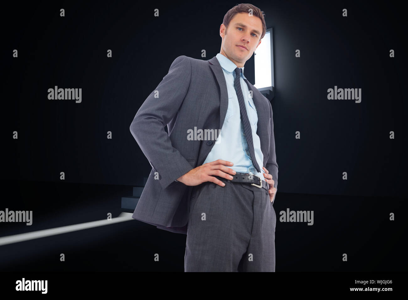 Stern businessman with hands on hips against door opening revealing ...