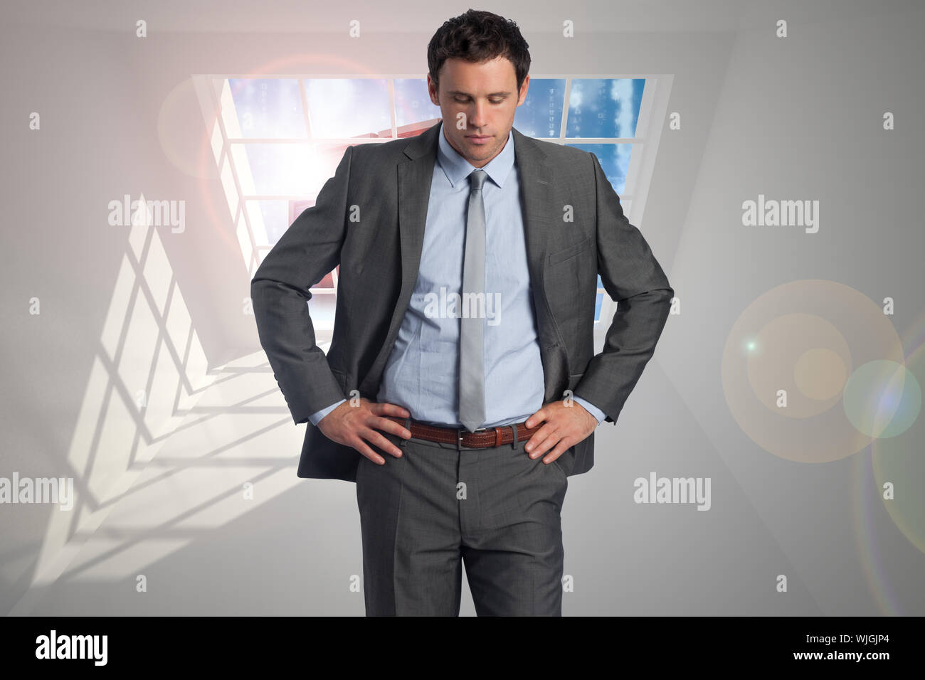 Serious businessman with hands on hips against server tower seen ...