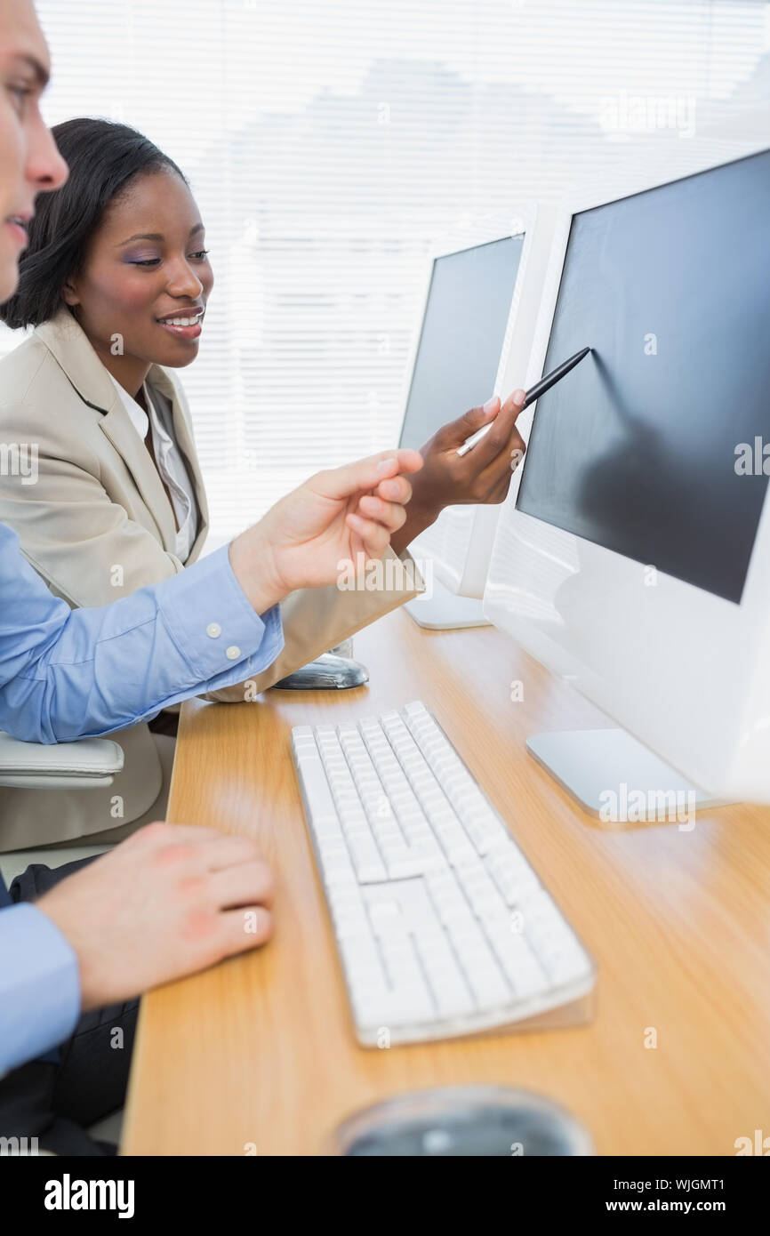Side view of business colleagues using computers at office desk Stock ...