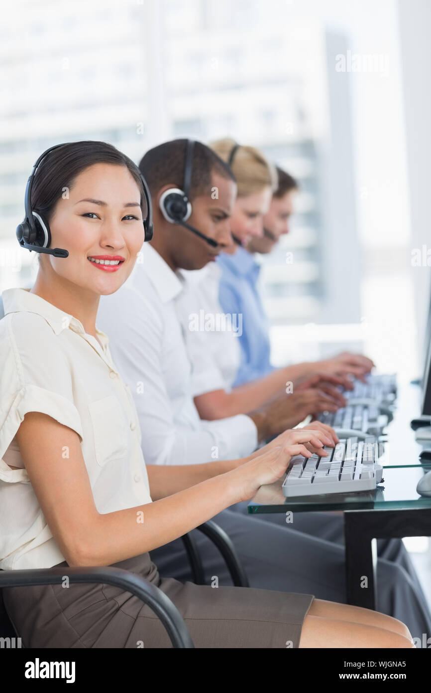 Side view portrait of business colleagues with headsets using computers ...