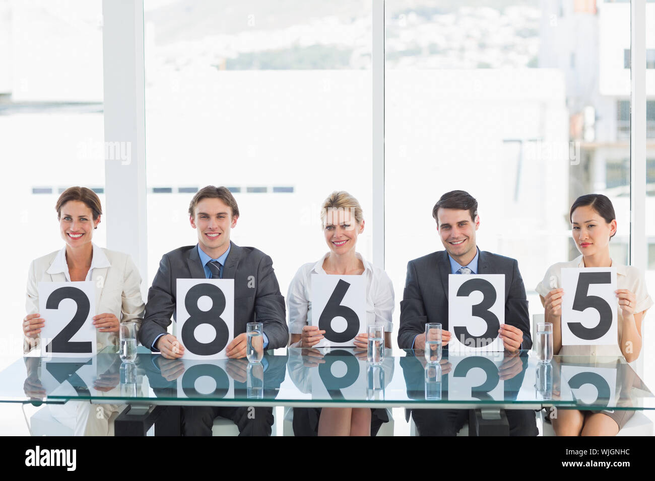 Portrait of a group of panel judges holding score signs Stock Photo - Alamy