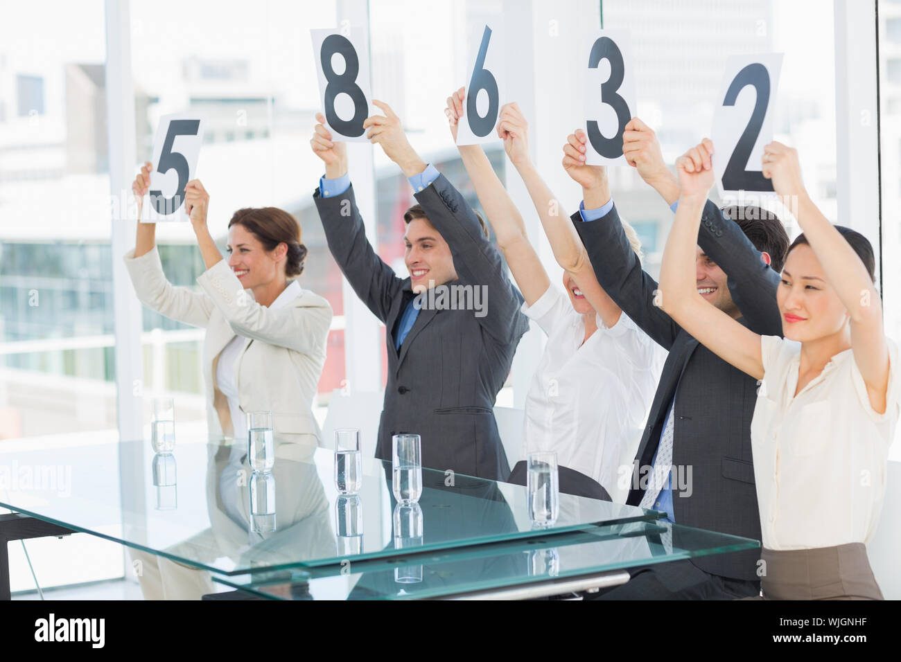 Group of panel judges in a row holding score signs Stock Photo - Alamy