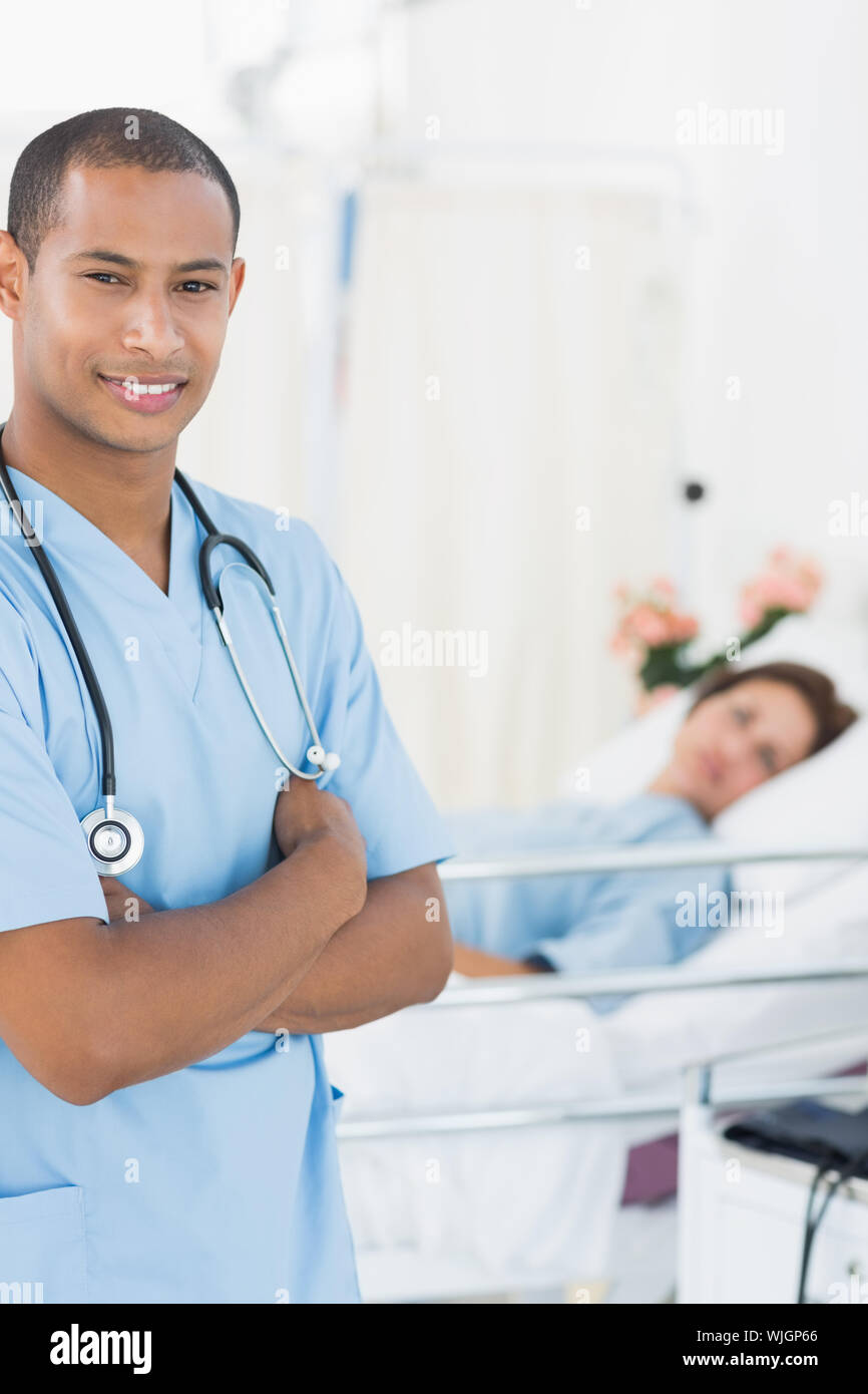 Portrait of a smiling surgeon with patient in background at hospital ...