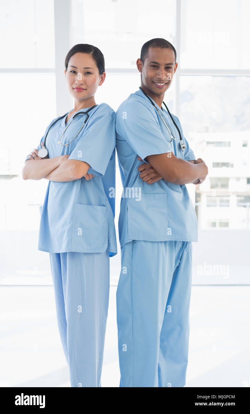 Portrait of two confident surgeons standing back to back in the ...