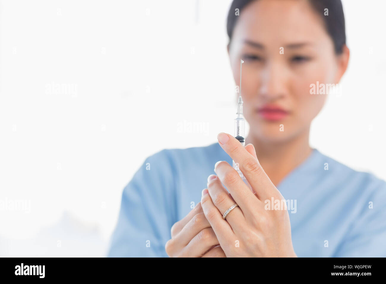 Serious female doctor holding an injection in the bright hospital Stock ...
