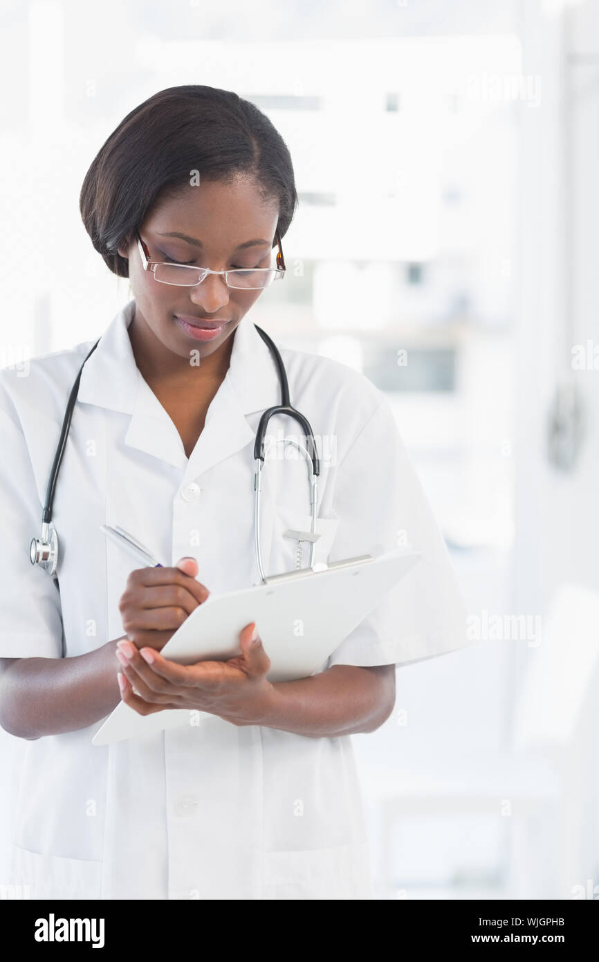 Female doctor writing report in the bright hospital Stock Photo - Alamy