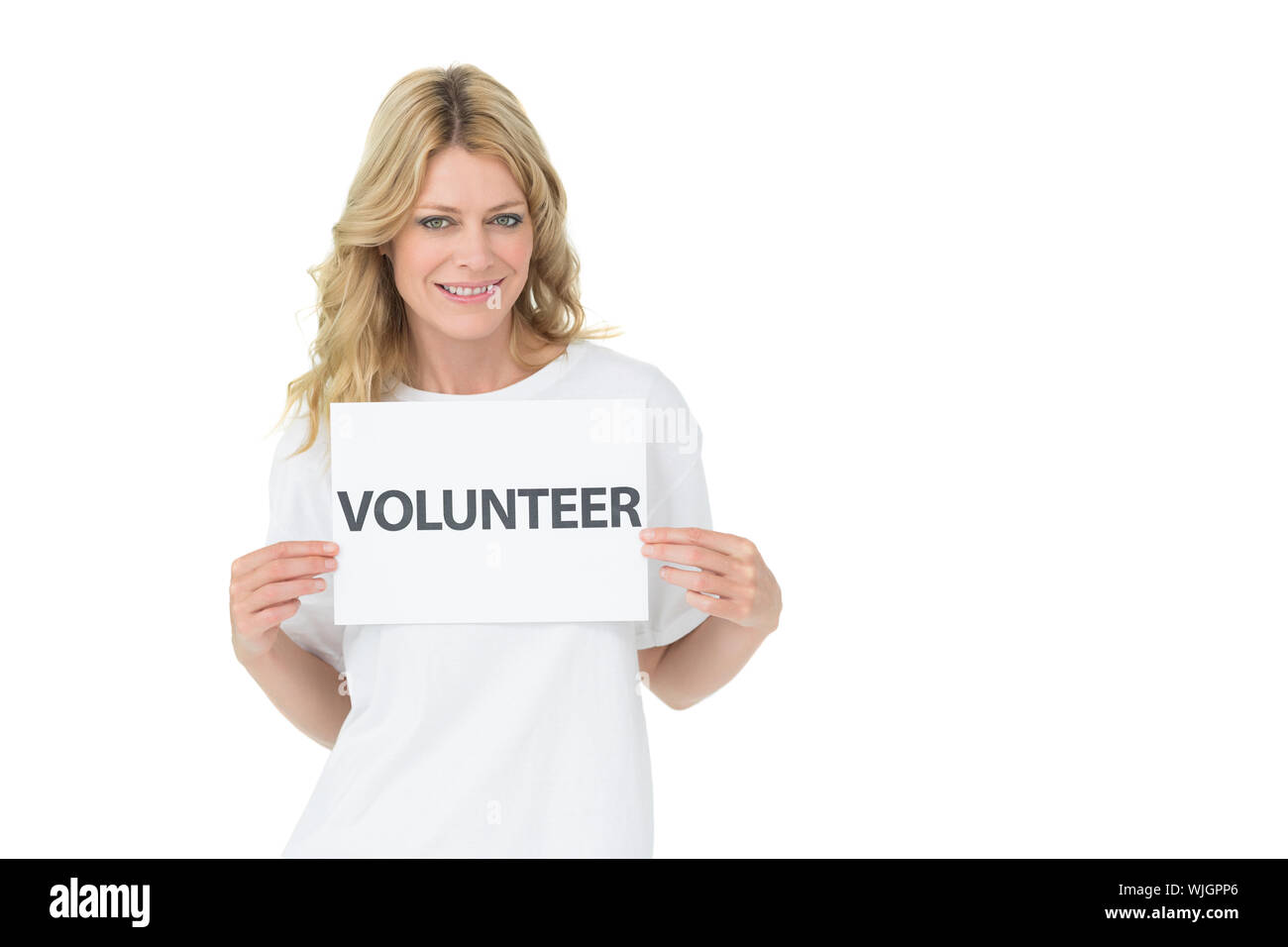 Portrait of a smiling young female volunteer holding placard over white ...