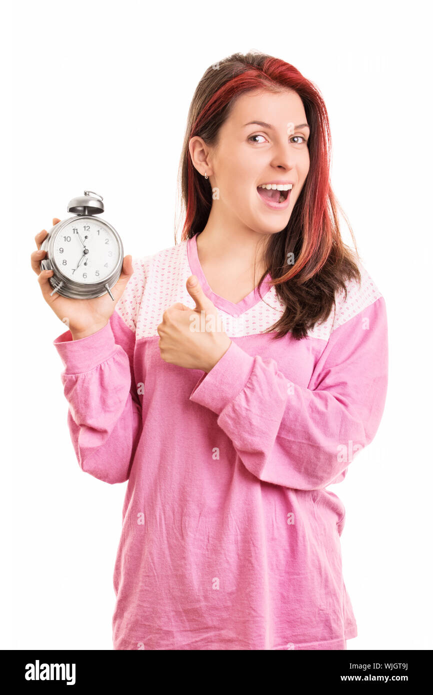 When timing is right. Smiling young girl in pink pajamas holding an ...
