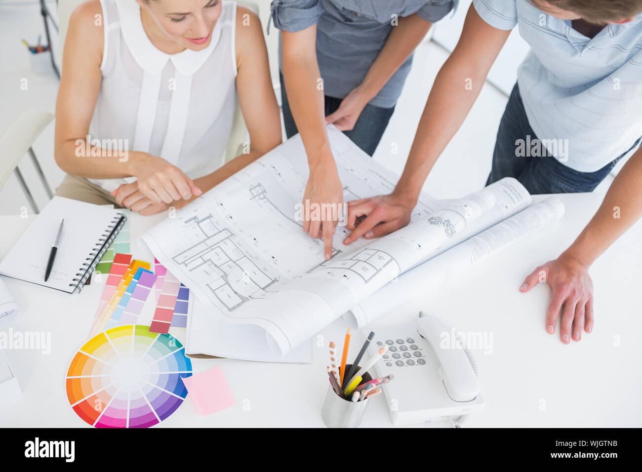 High angle view mid section of artists working on designs in a bright ...