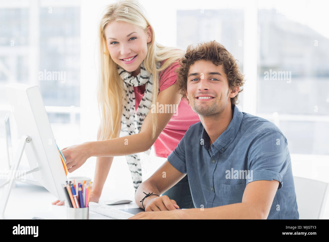 Side view portrait of a casual business couple using computer in a ...