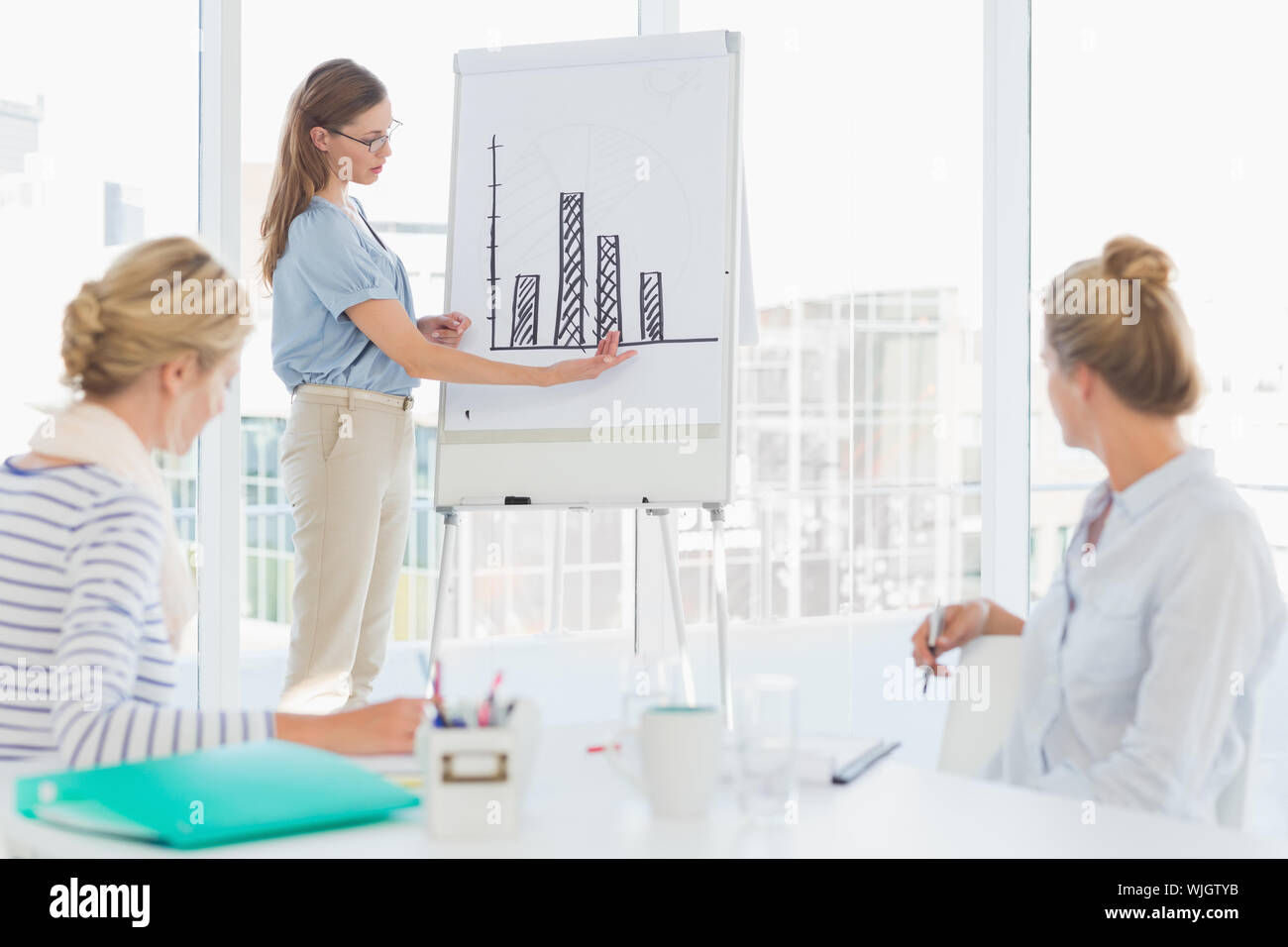 Young casual businesswoman presenting new project to partners Stock ...