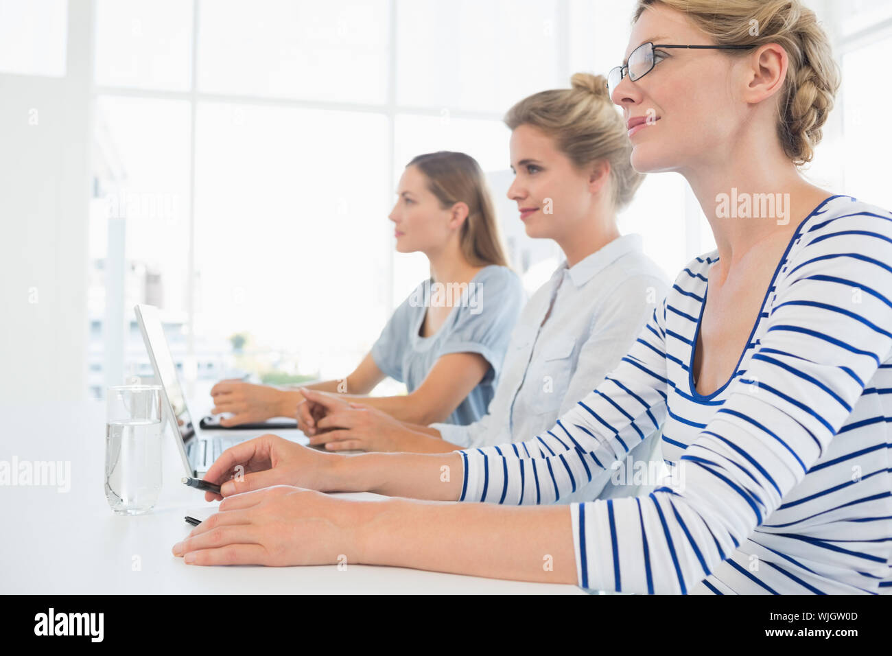 Concentrated three young people working in a bright office Stock Photo ...