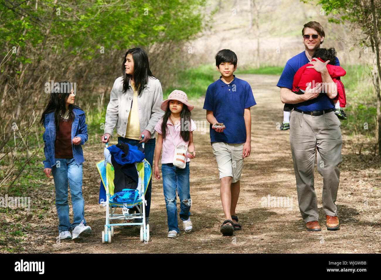 Family walking along quiet country path through woods Stock Photo - Alamy