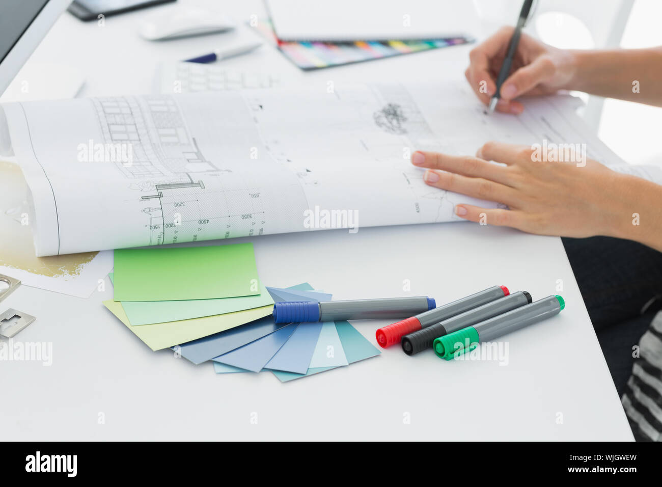 Close-up side view of an artist drawing something on paper with pen at ...