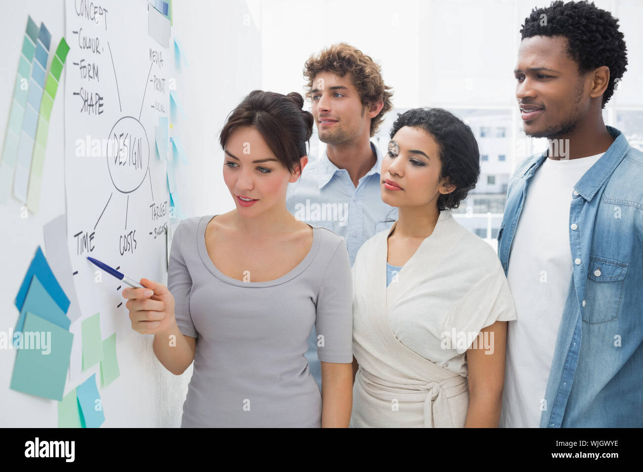 Group of artists in discussion in front of whiteboard at office Stock ...