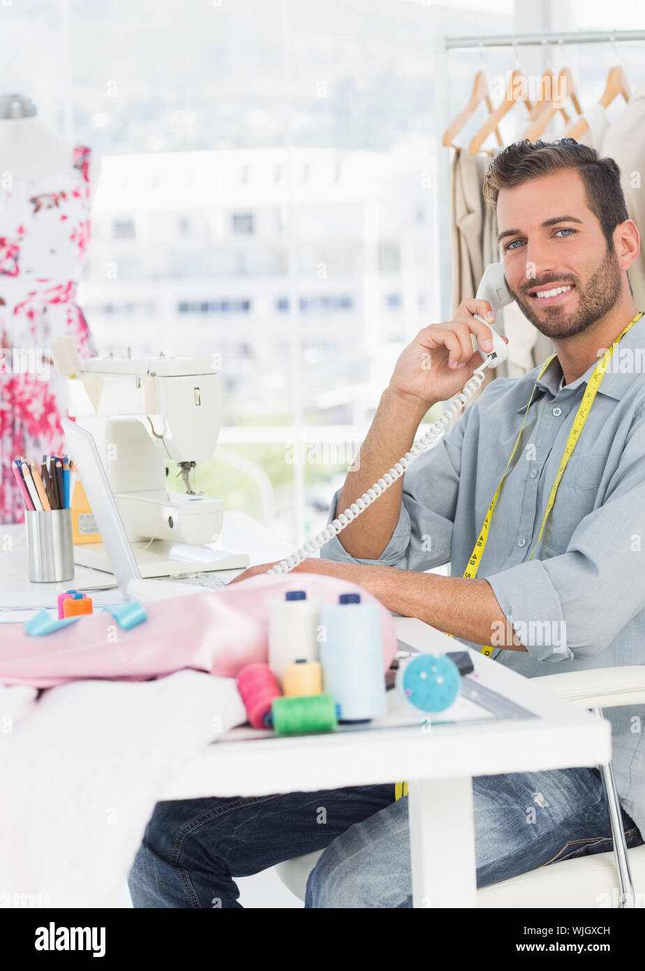 Side view portrait of a young male fashion designer using phone in the ...
