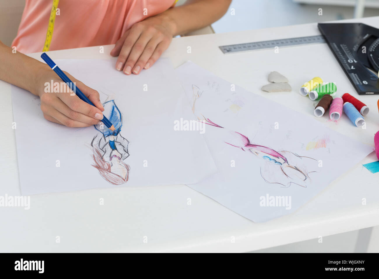 Close-up mid section of a female fashion designer working on her ...