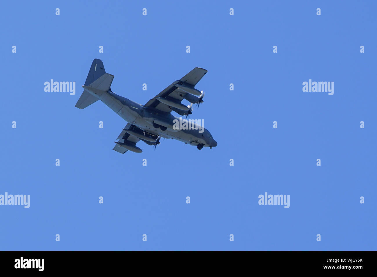 grey military transport plane fly on blue sky background Stock Photo ...