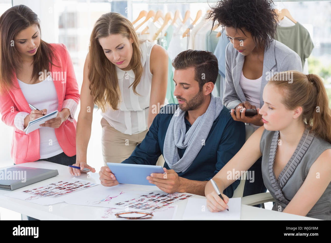 Group of fashion designers discussing designs in a studio Stock Photo ...