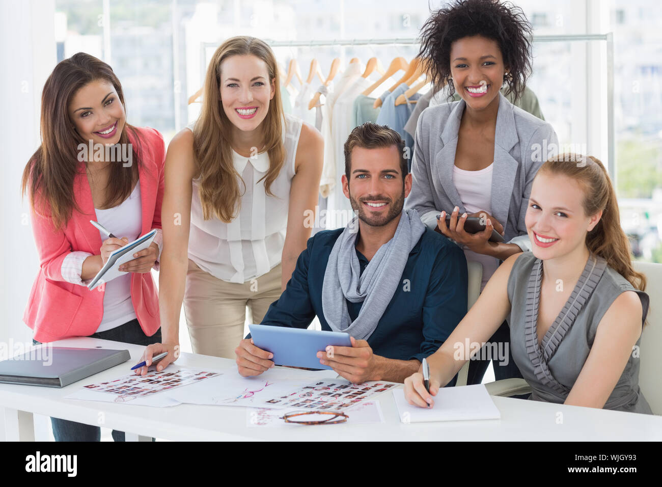 Group portrait of fashion designers discussing designs in a studio ...