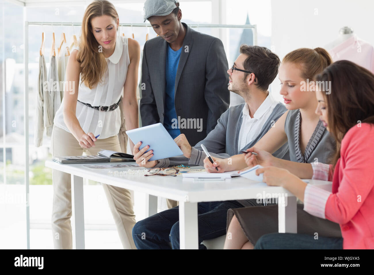 Group of fashion designers discussing designs in a studio Stock Photo ...