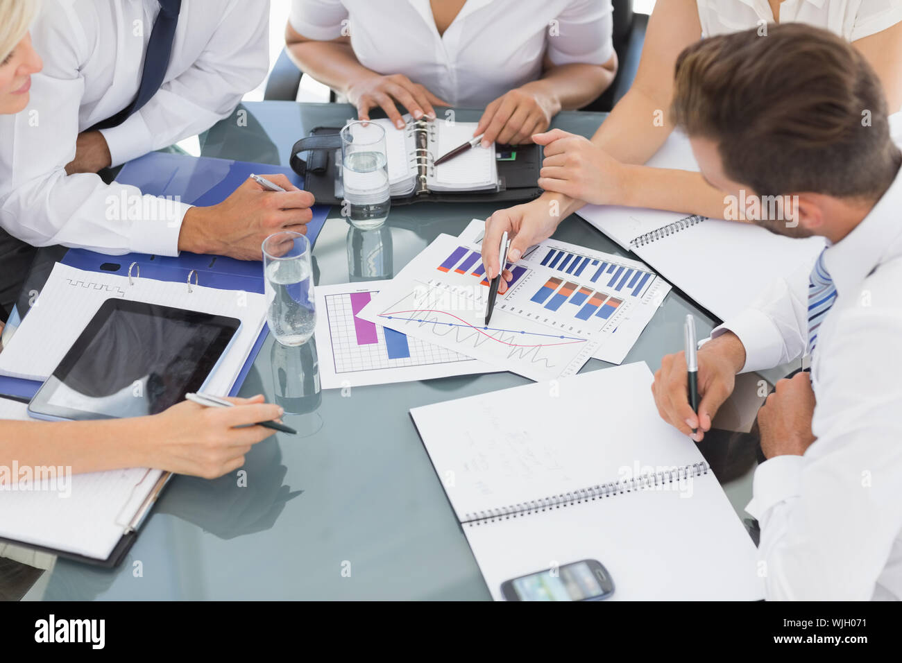 Mid section of young well dressed business people in discussion at a ...